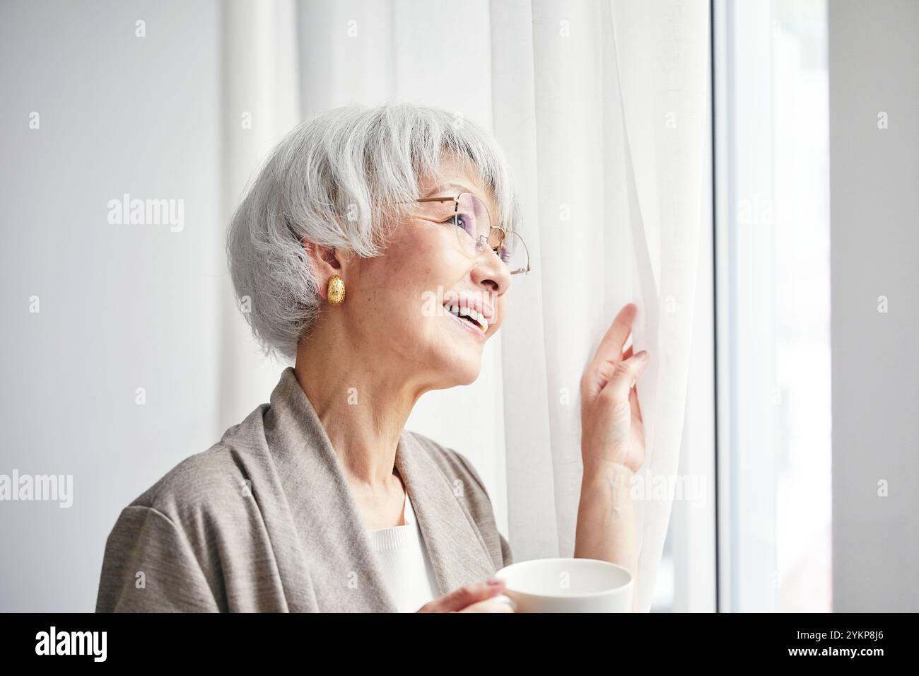 Senior woman opening curtains Stock Photo - Alamy