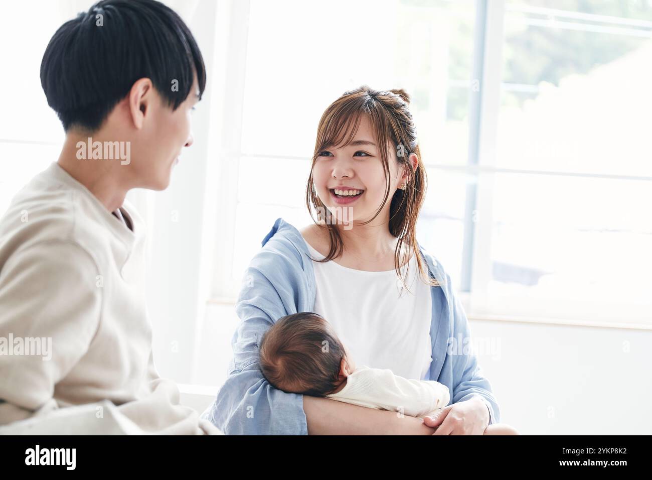 Three parents and their children relaxing in the living room Stock ...