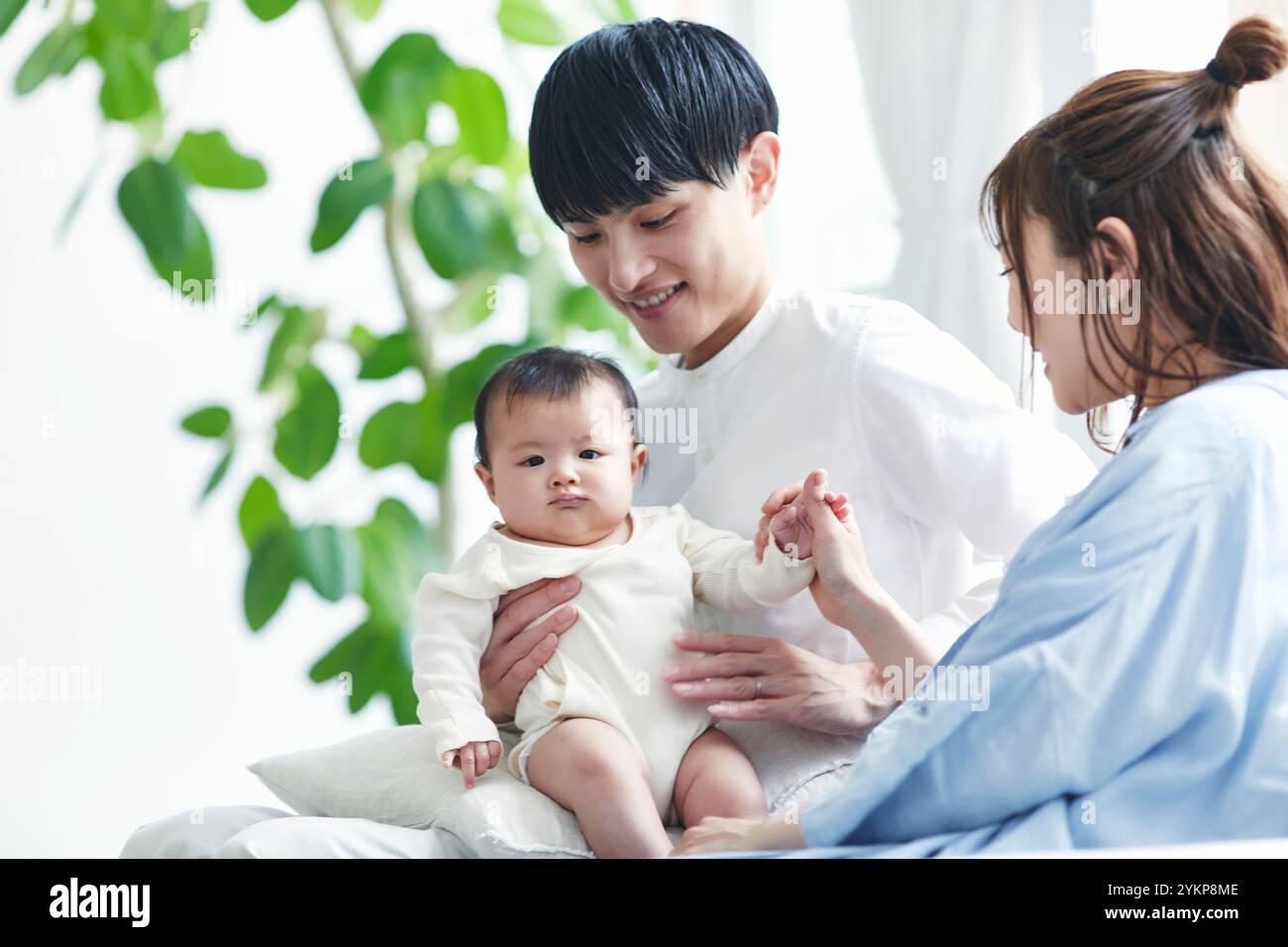 Three parents and their children relaxing in the living room Stock ...