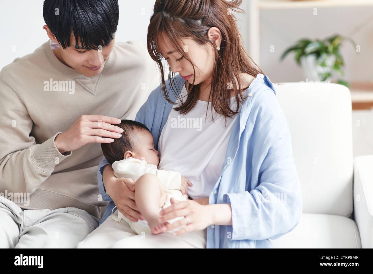 Three parents and their children relaxing in the living room Stock ...