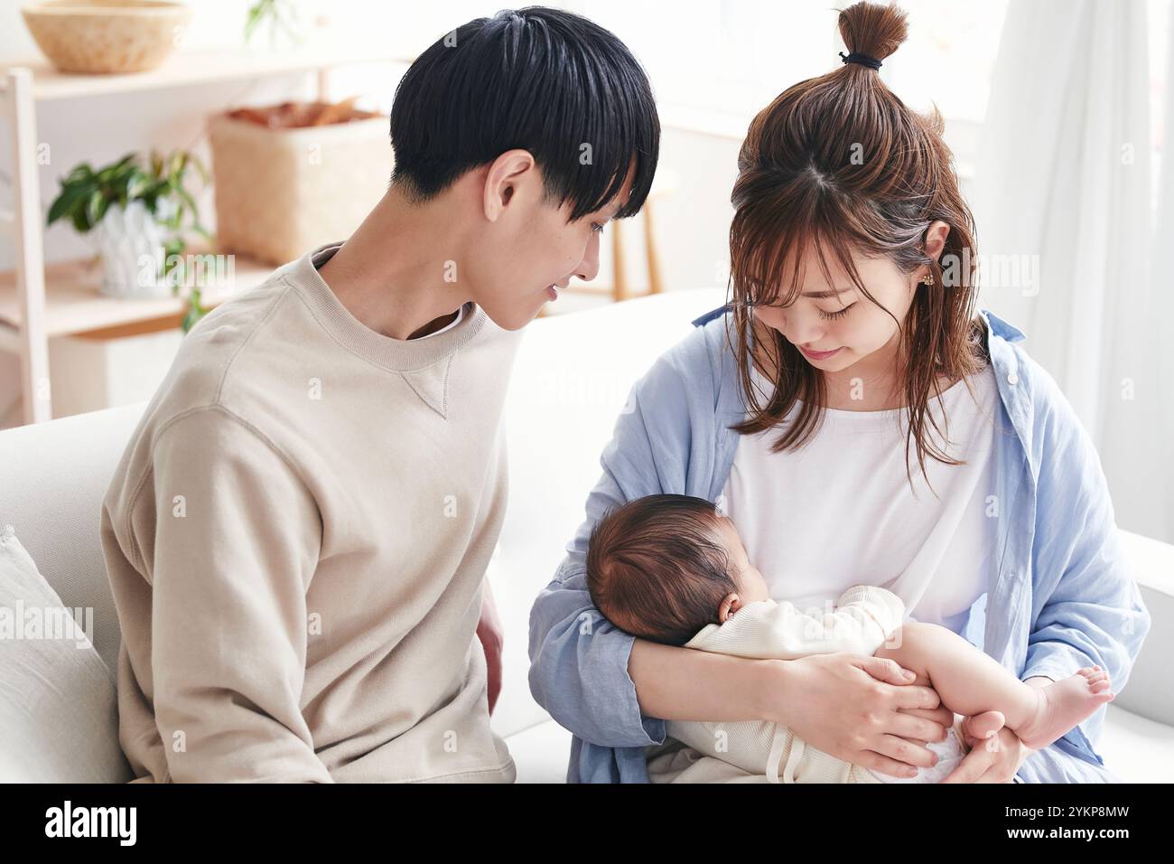 Three parents and their children relaxing in the living room Stock ...