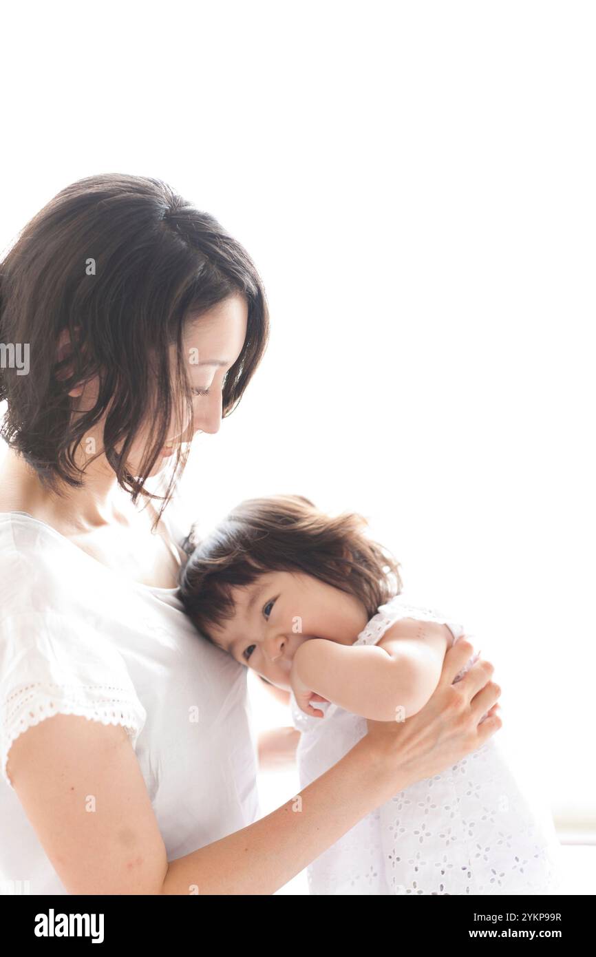 Smiling baby girl being pampered and carried by her mother Stock Photo ...