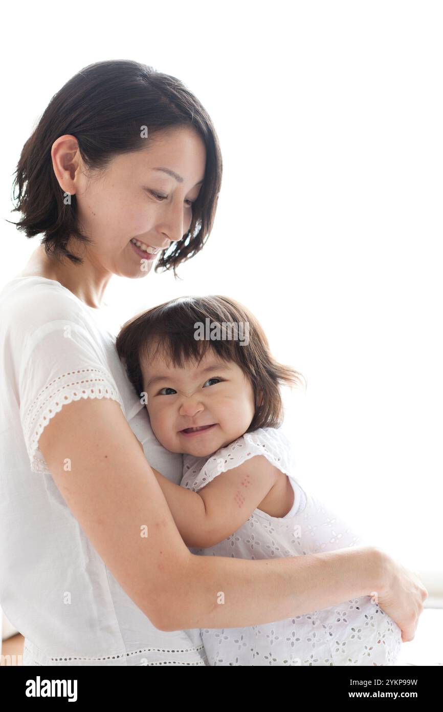 Smiling baby girl being pampered and carried by her mother Stock Photo ...