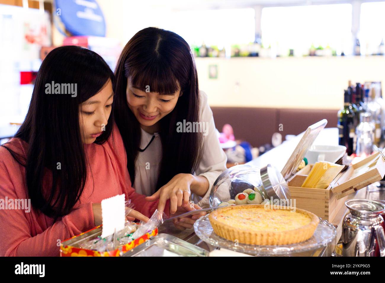 Two women choosing various sweets at the counter of a café Stock Photo - Alamy