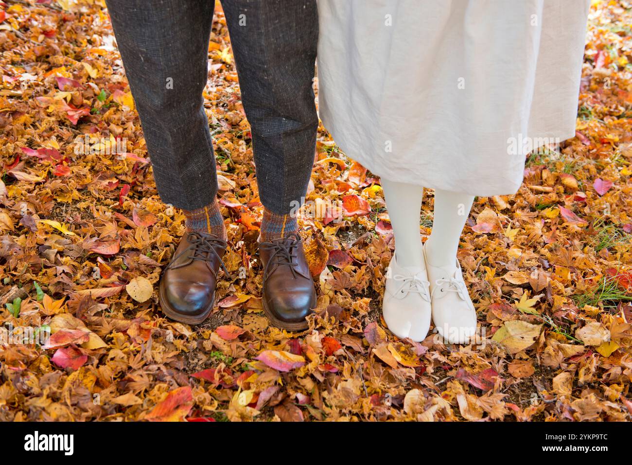 Fallen leaves and feet of man and woman in formal dress Stock Photo - Alamy