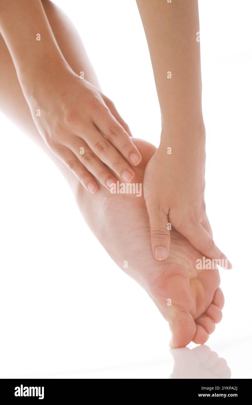 Woman massaging feet with both hands Stock Photo - Alamy