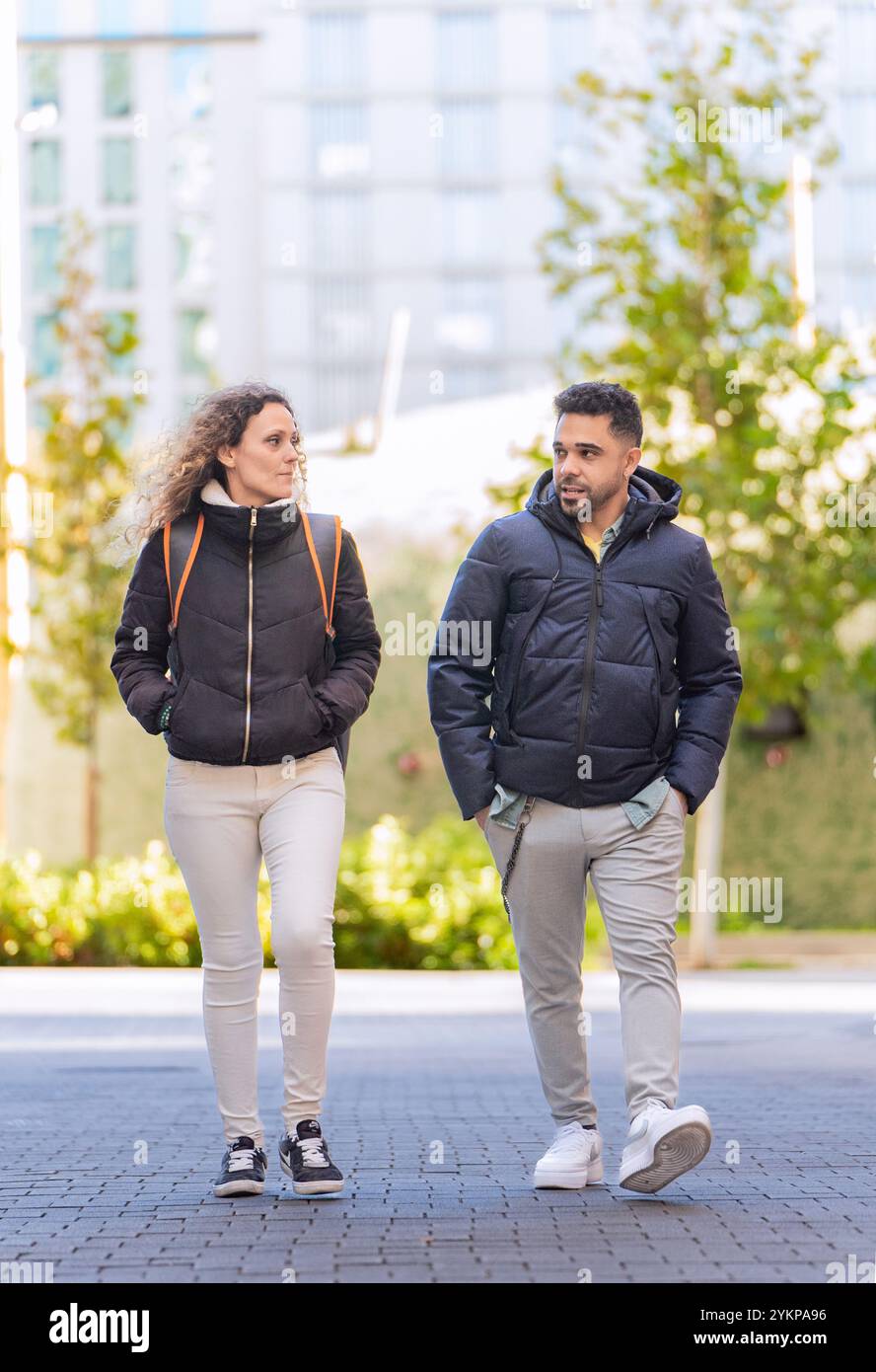 Two university students walking and talking together between classes on ...