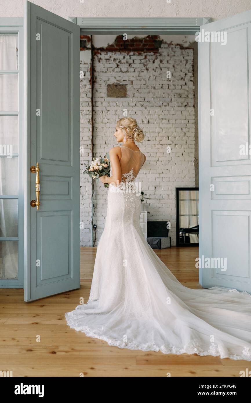 An elegant bride in a wedding dress at the open doors Stock Photo - Alamy