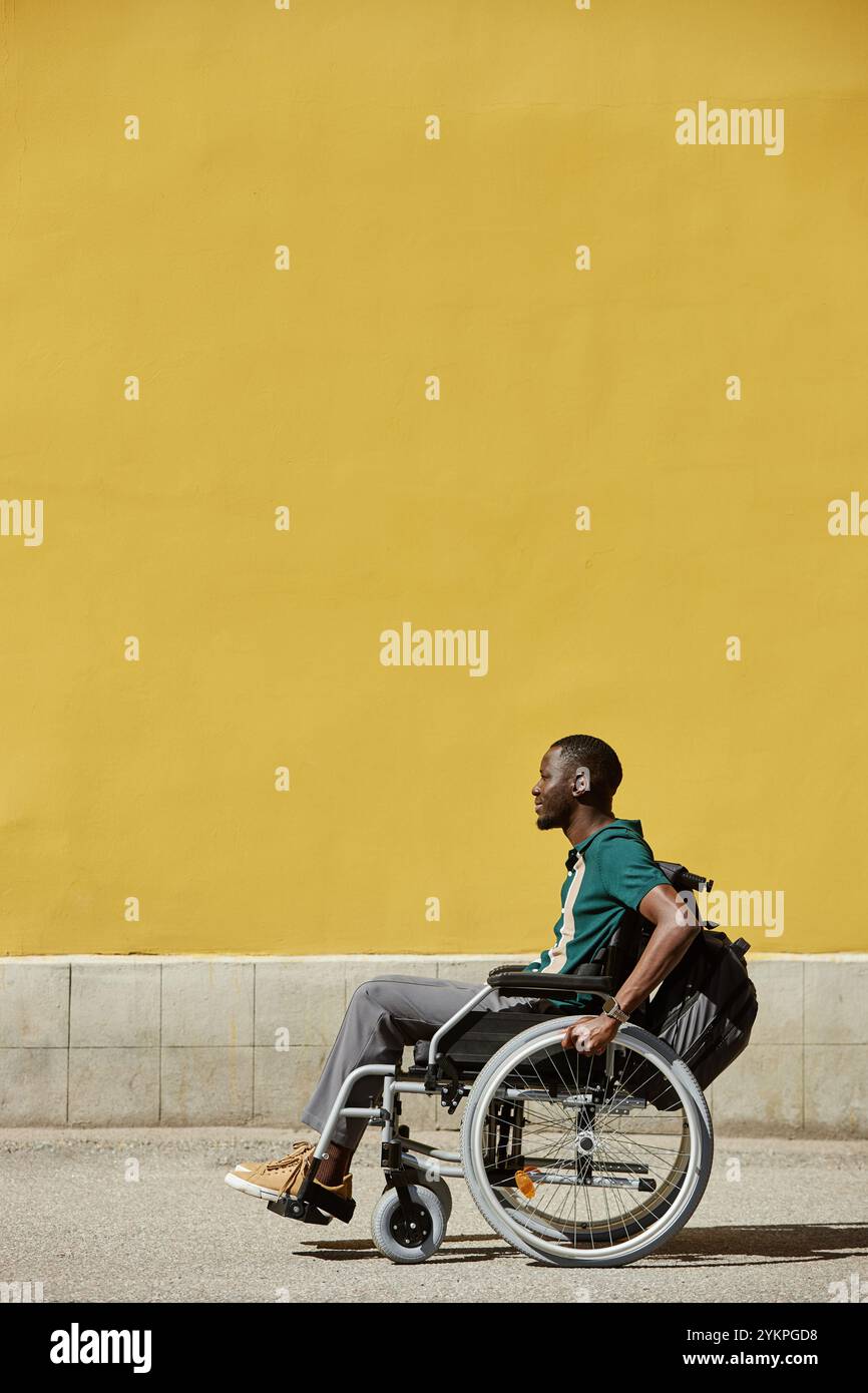Vertical side view of African American man with disability using ...