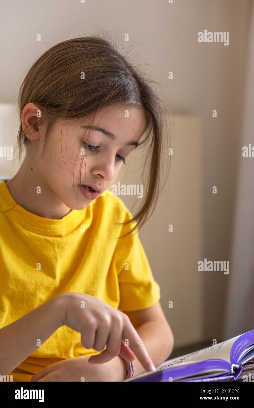 An interested and focused girl is reading a book. Emotion concept Stock ...