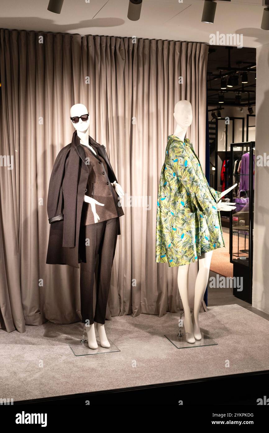 Female mannequins in store glass window display dressed casual autumn ...