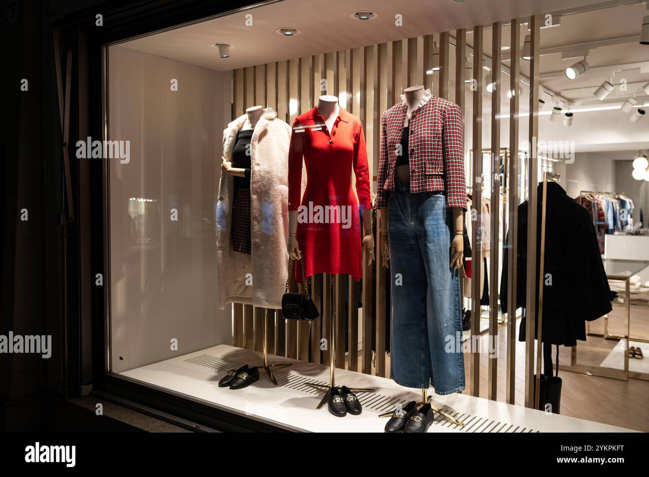 Female mannequins in store glass window display dressed casual autumn — winter elegant clothing ...