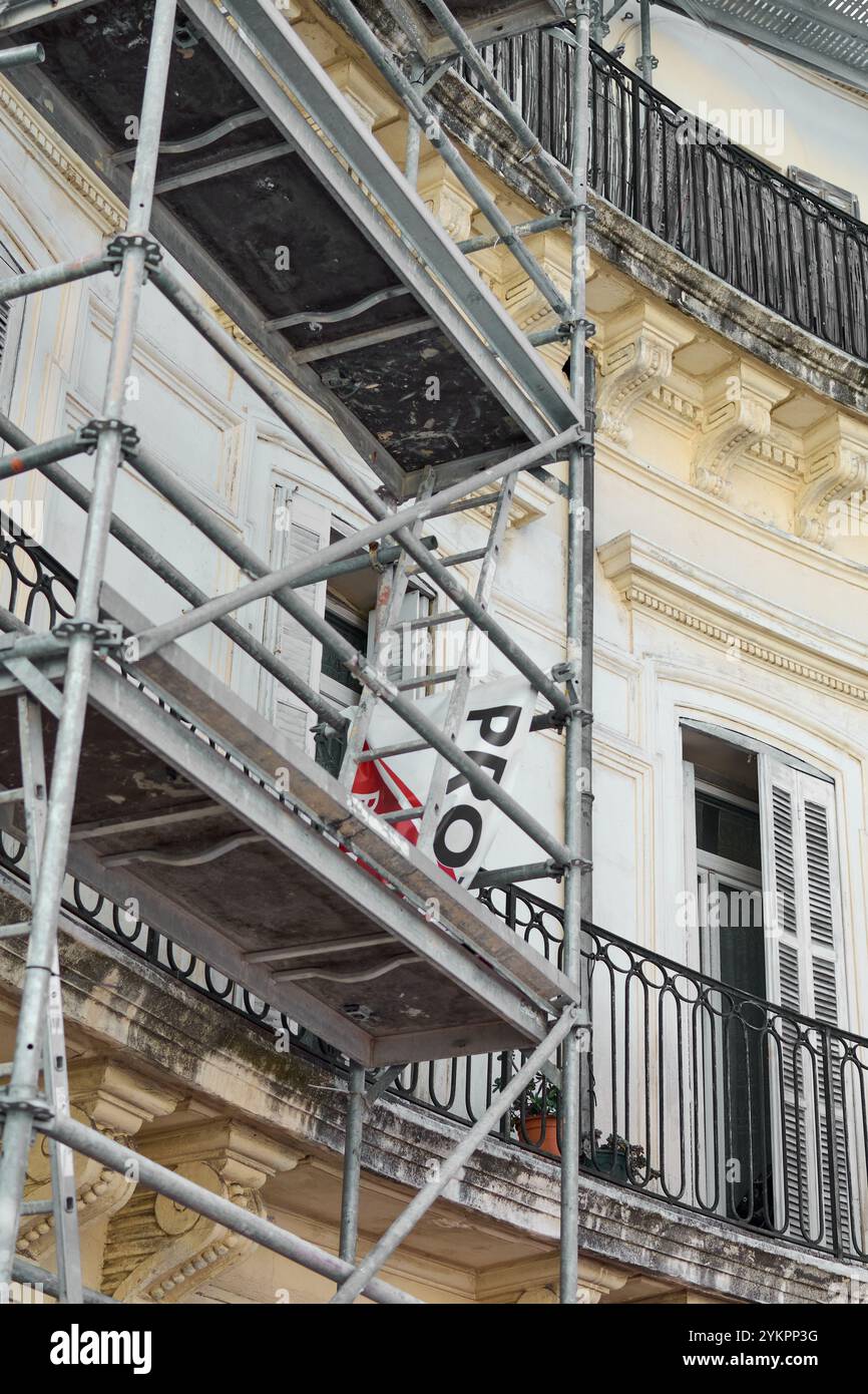 Close-up of scaffolding on a classic building with ornate balconies and ...