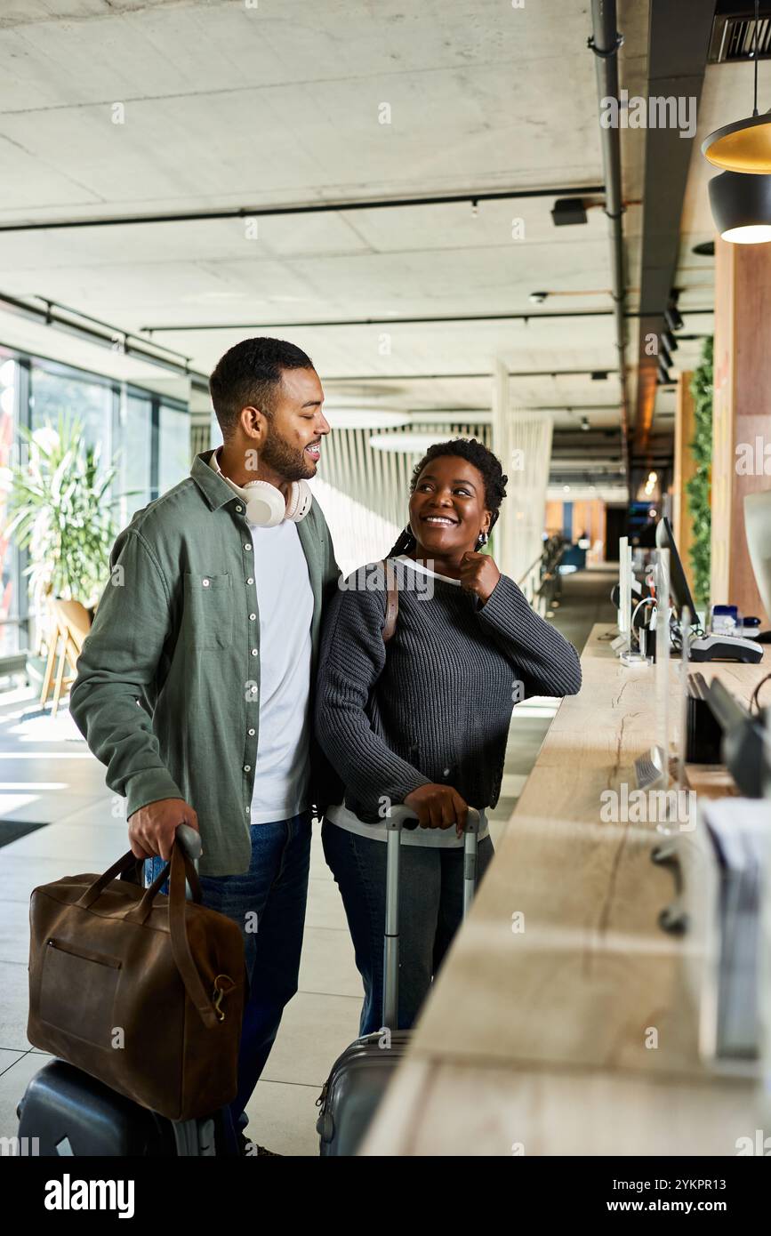 A happy young couple arrives at a hotel, eager to start their vacation ...