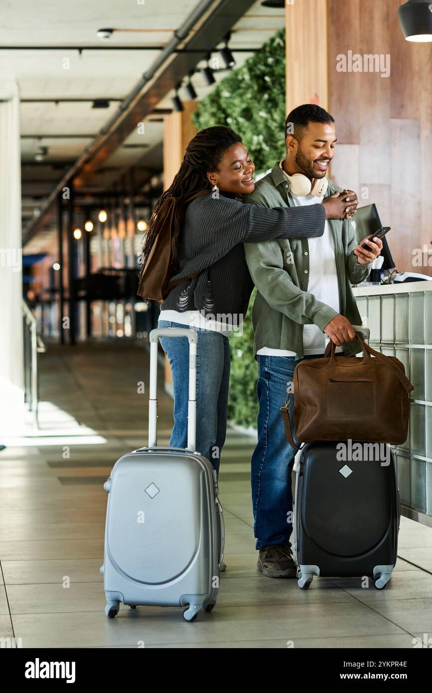 A joyful young couple arrives at their hotel, sharing smiles while ...
