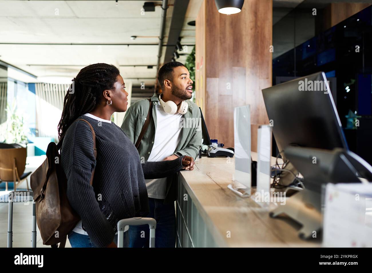 A young couple expresses excitement as they prepare for their vacation ...