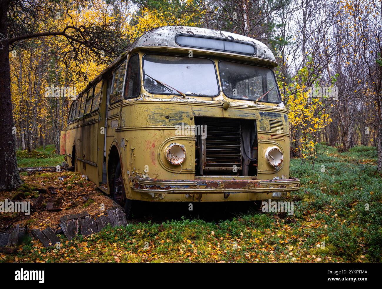 An old, abandoned, rusty bus left in the forest of Northern Norway ...