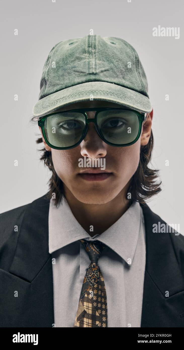 Close-up portrait of stylish young guy wearing green cap and oversized ...