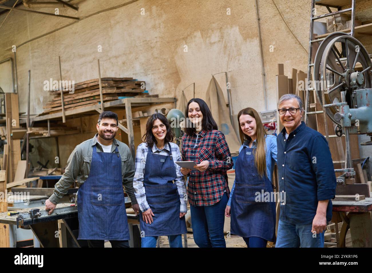 A diverse group of lumberyard workers of different ages collaborating ...