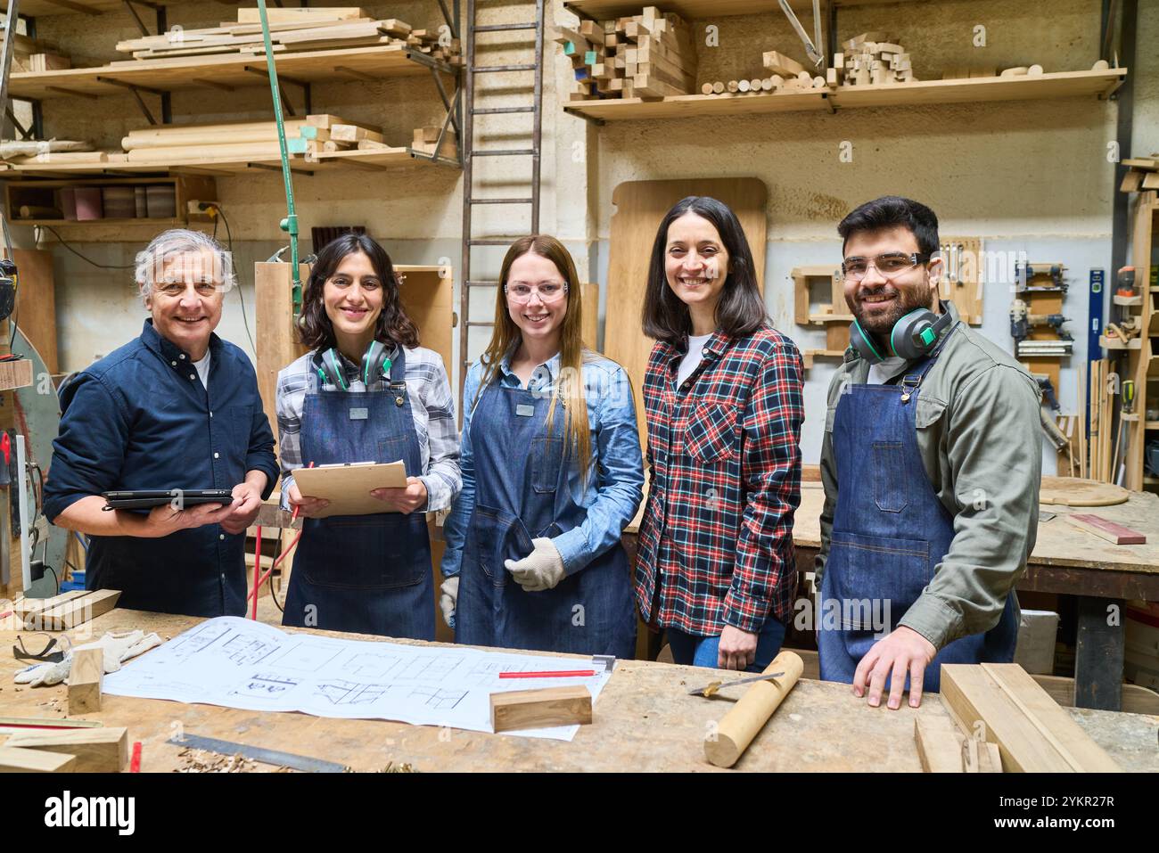 A group of diverse professionals in a lumberyard working together. The ...