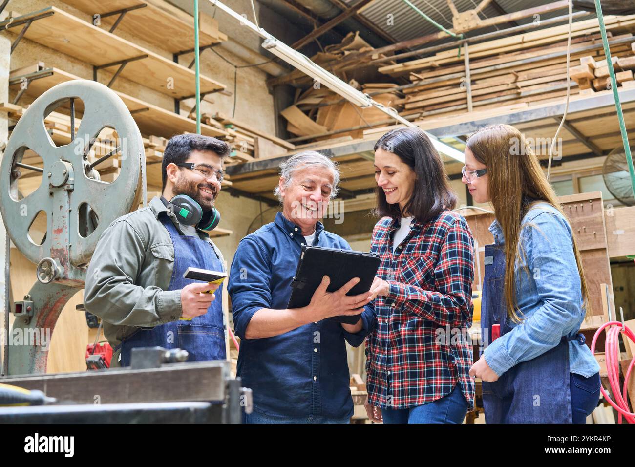 A diverse group of coworkers collaborates in a lumberyard, highlighting ...