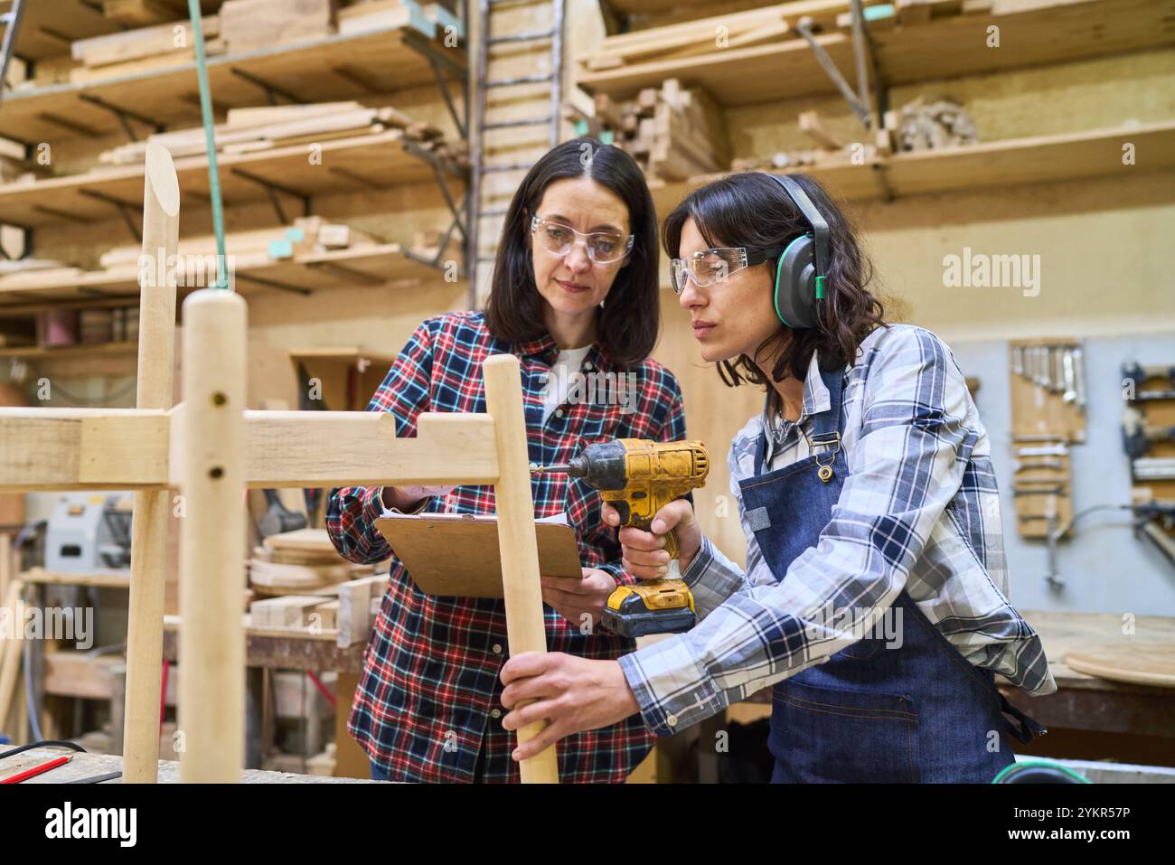 Two people collaborating in a lumber workshop, focusing on teamwork and ...