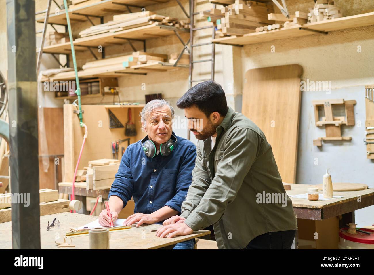 A young apprentice listens attentively to an experienced mentor while ...