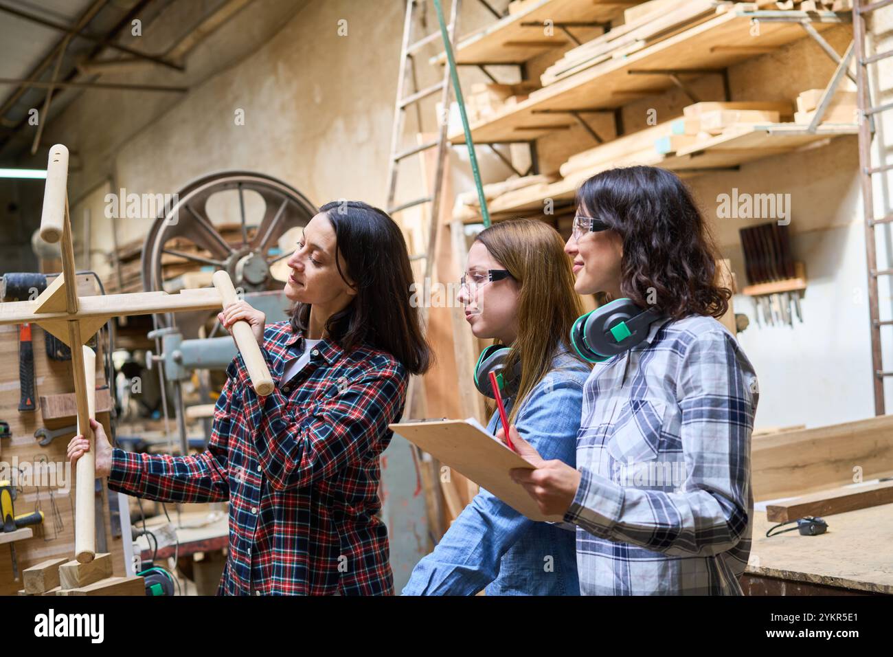 A diverse group of individuals work together in a lumberyard, focusing ...