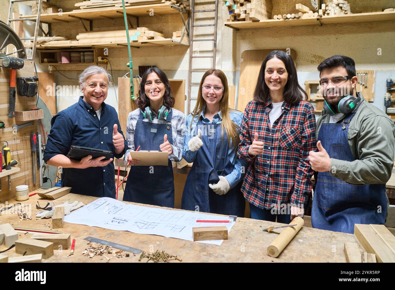 A diverse group of apprentices and seasoned workers collaborate in a ...