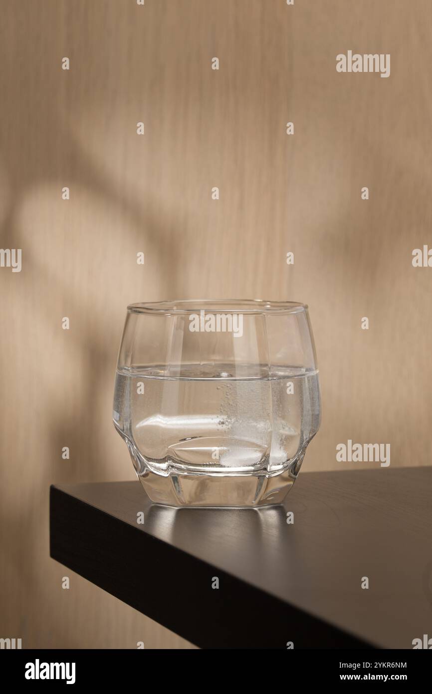 An effervescent mucolytic tablet dissolves in a glass of drinking water ...