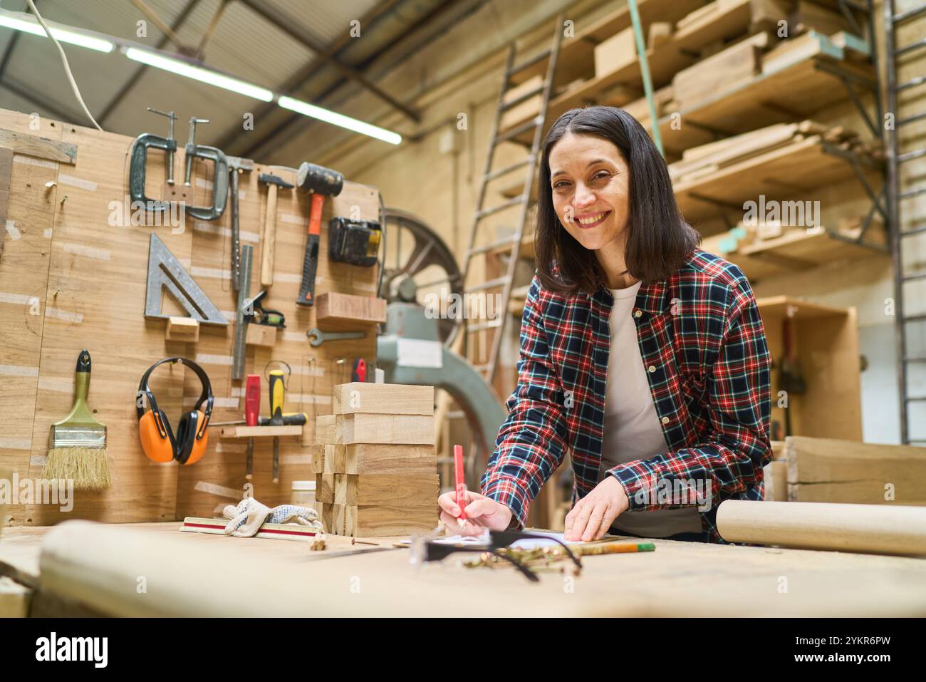 A woman is engaging in carpentry work at a lumberyard, surrounded by ...