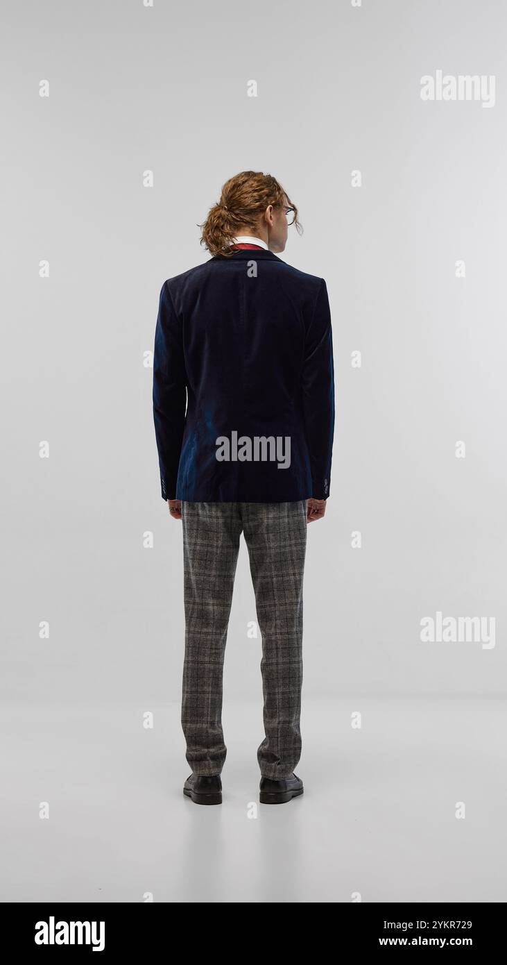 Full-length back view of young man in navy blue velvet blazer ...