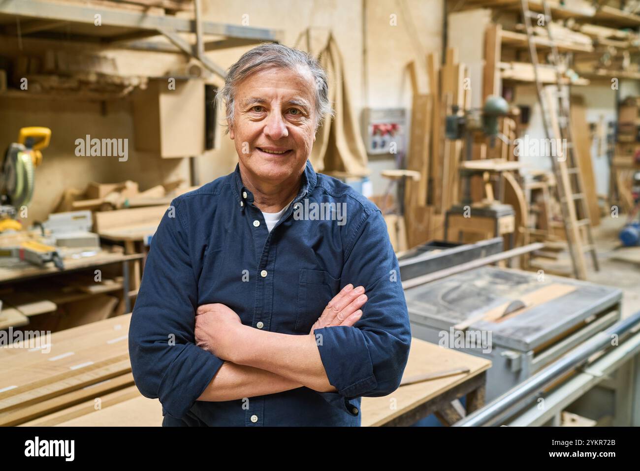 A senior craftsman stands confidently in a lumberyard surrounded by ...