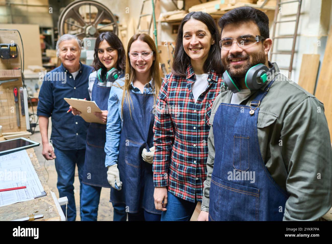 A diverse team of skilled lumberyard workers smiling confidently ...