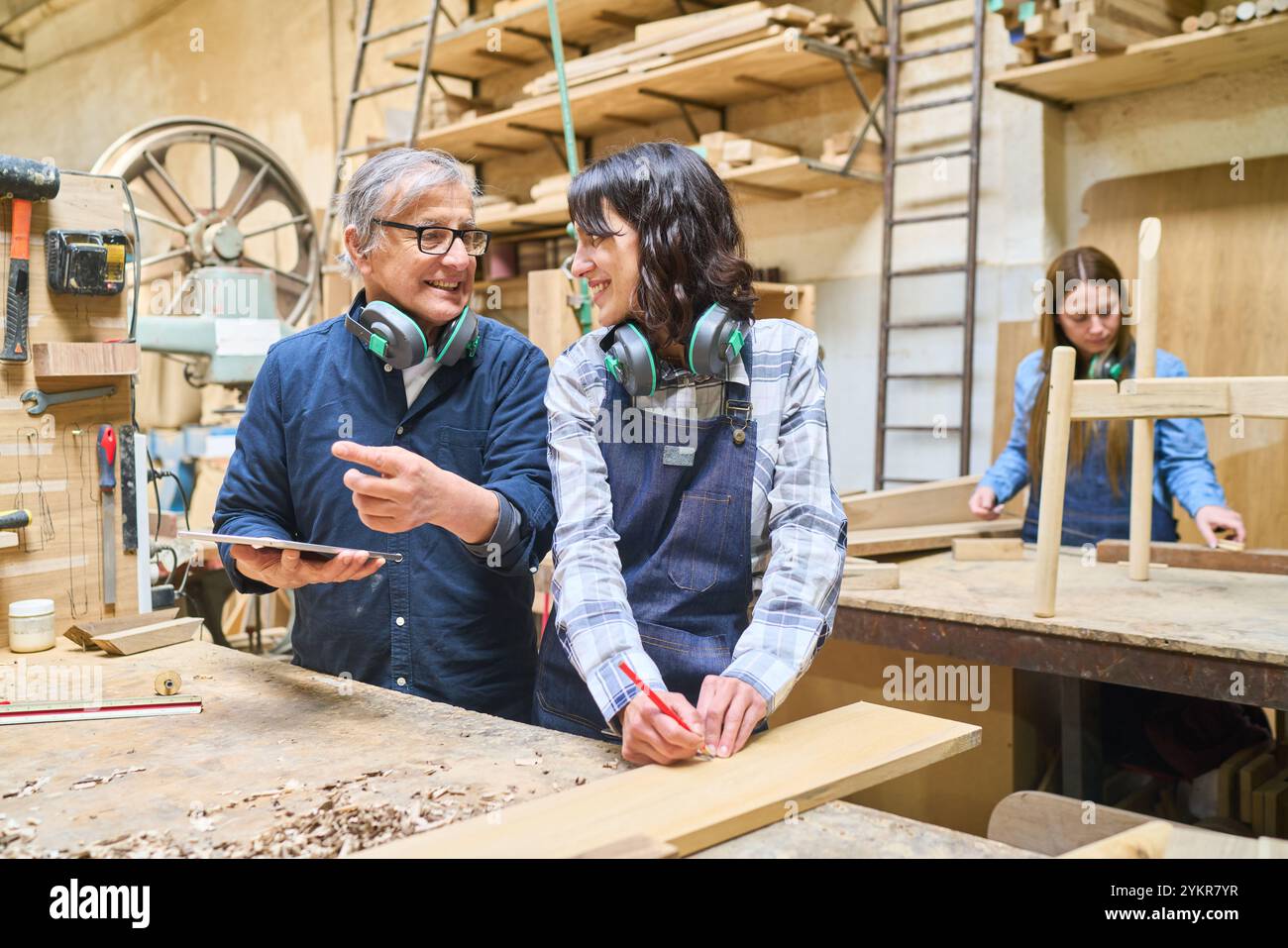 A seasoned craftsman mentors a younger apprentice in a lively ...