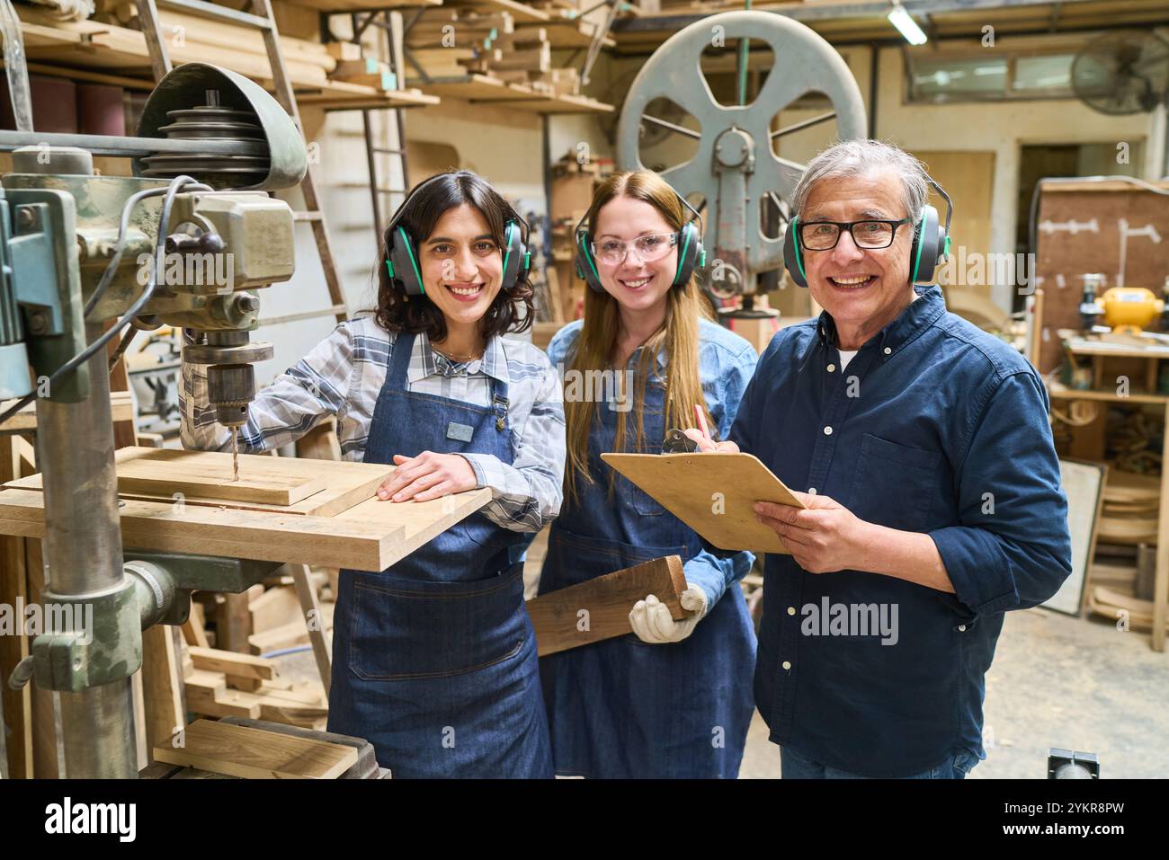 Three diverse team members engage in woodworking at a lumberyard ...