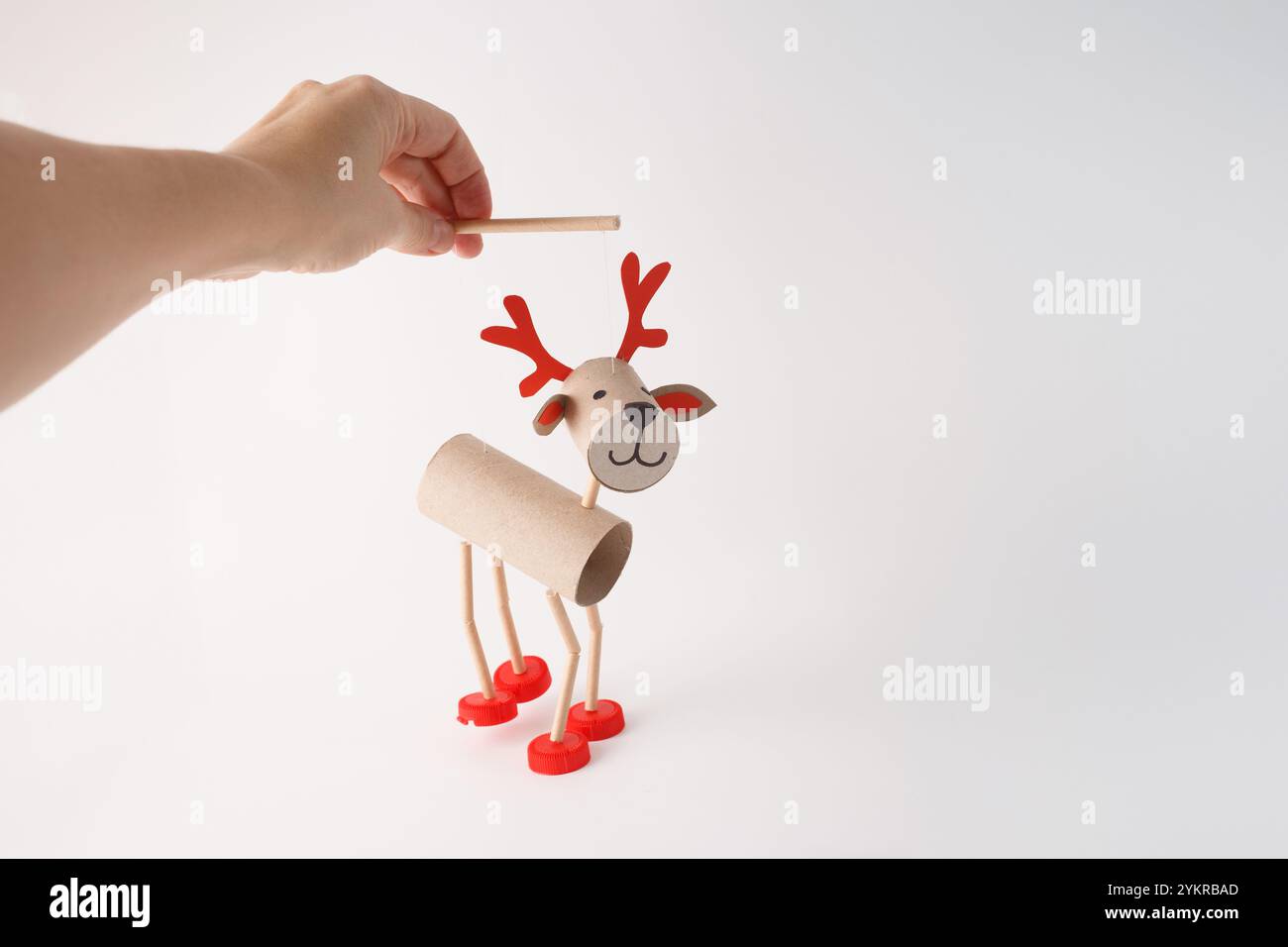 Hand holding DIY reindeer puppet made from cardboard tubes, plastic ...