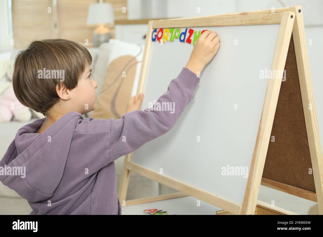 Little boy learning alphabet with magnetic letters indoors Stock Photo ...