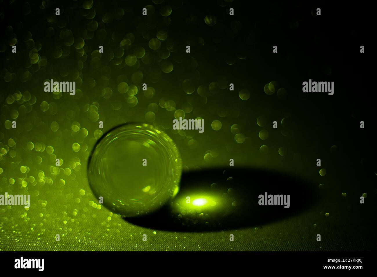Green glitter reflections thru a lens ball, on dark green defocused ...