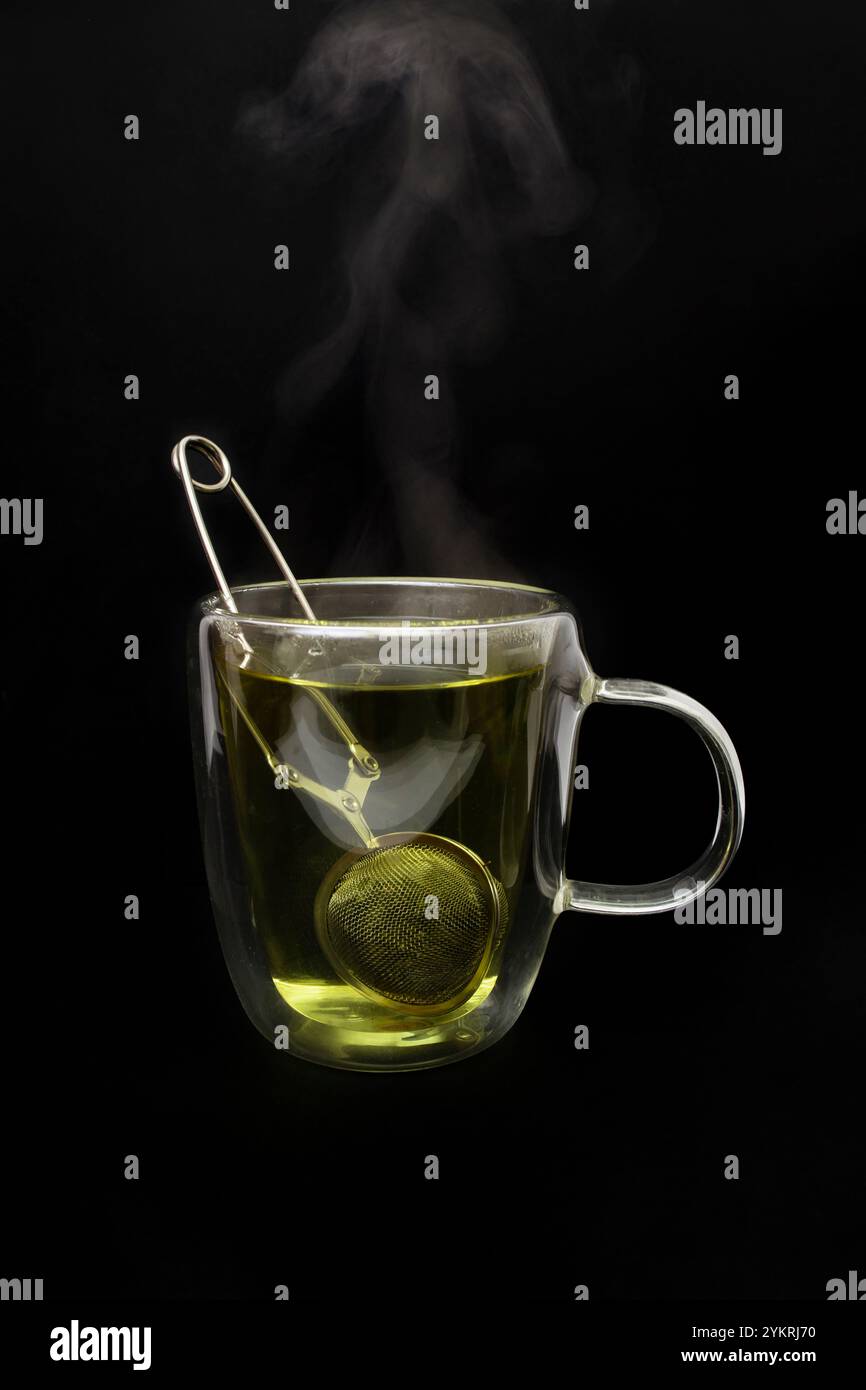 Double transparent glass mug, with green tea and silver clamp tea ...