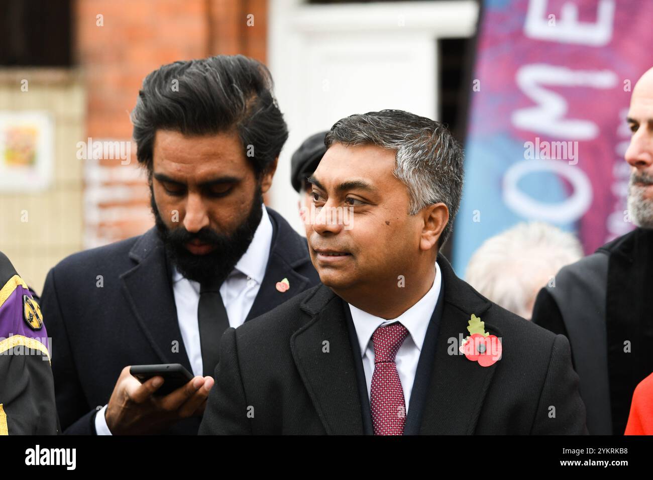 mp jeevun sandher (left) is looking at his phone at loughborough ...