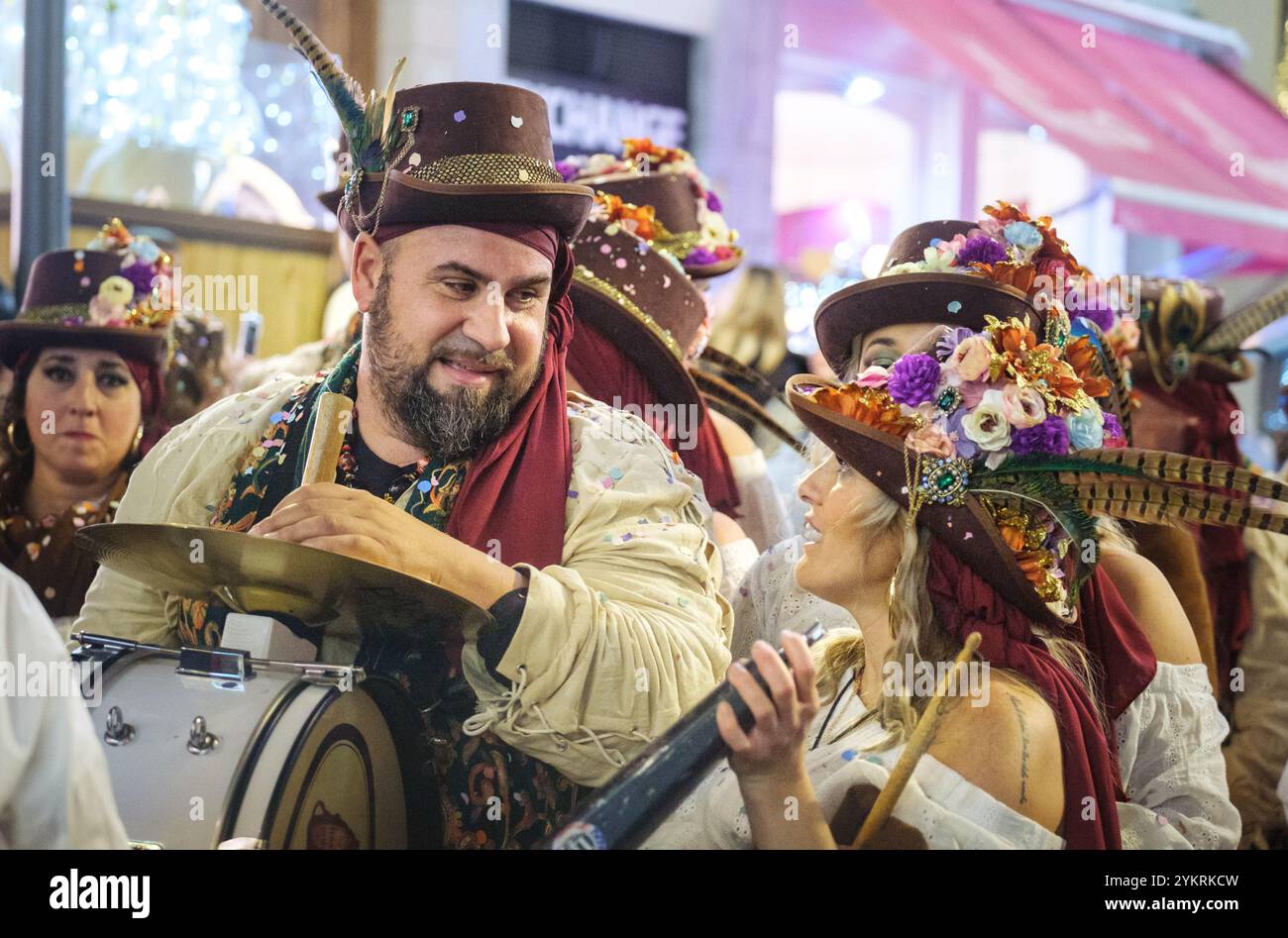 This image shows a group of people in festive attire that includes ...