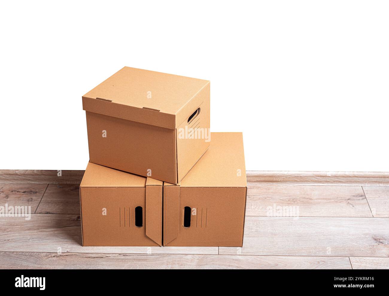 Cardboard boxes on the floor against a white wall Stock Photo - Alamy