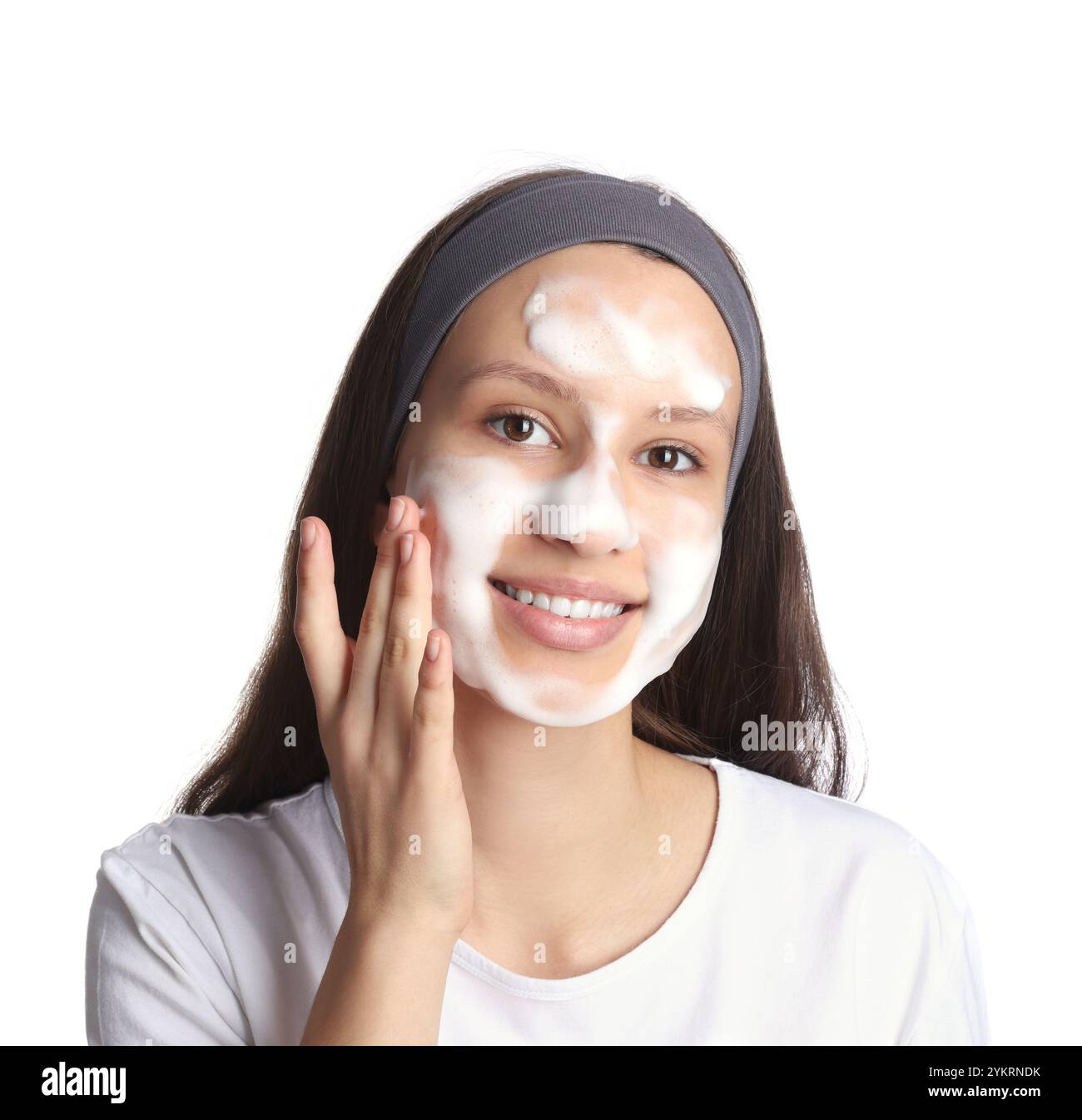 Teenage girl washing her face with cleanser on white background ...