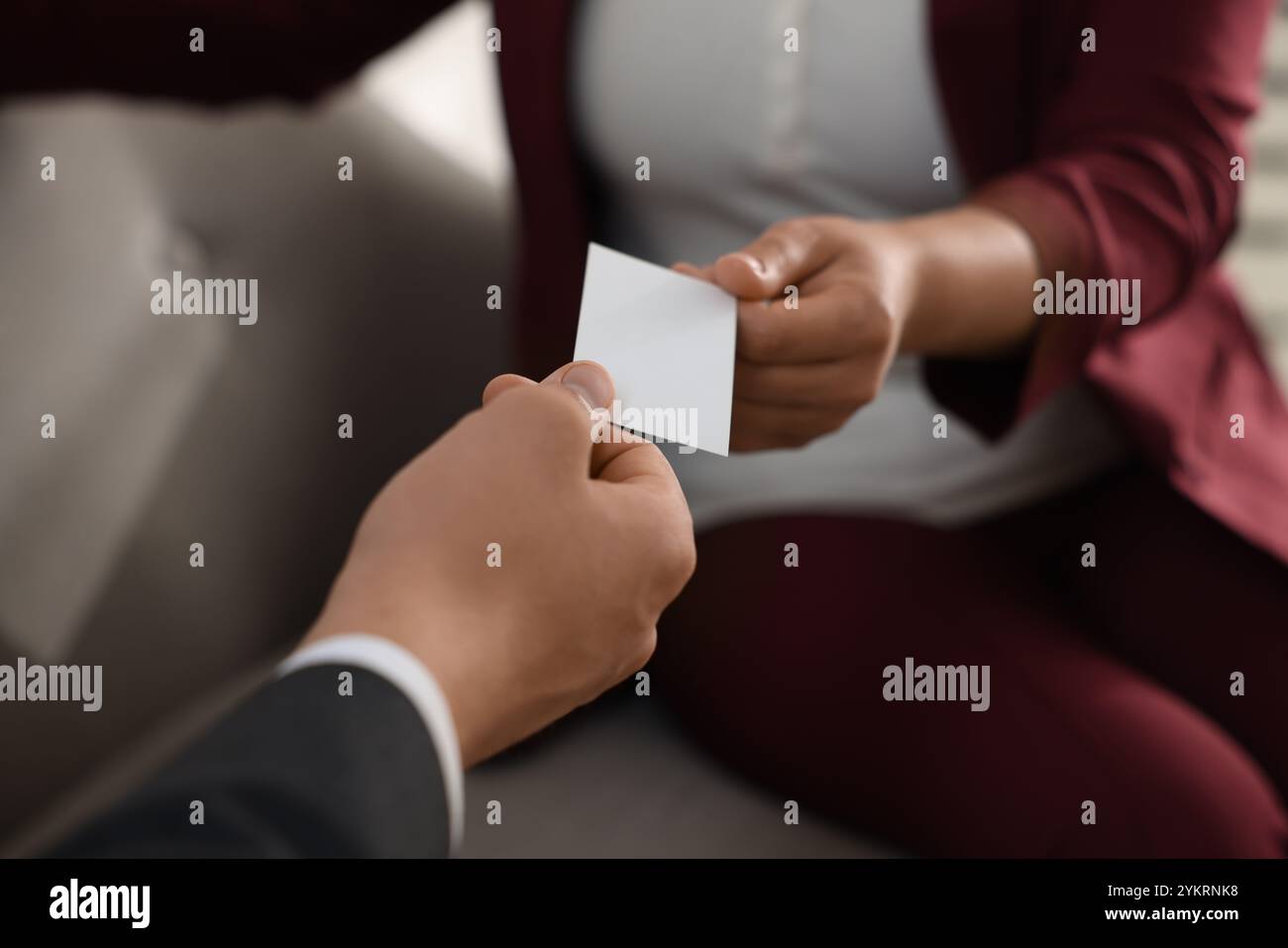 Woman giving business card to man in office, closeup. Mockup for design ...