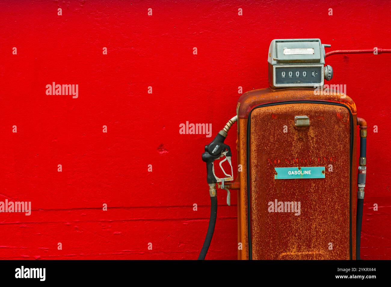 Rusty old fuel pump in front of red concrete wall on Japonski Island ...