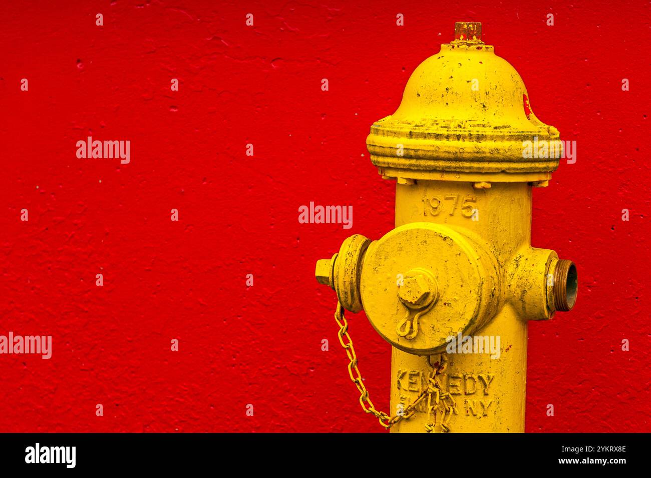Old yellow fire hydrant in front of red concrete wall on Japonski ...