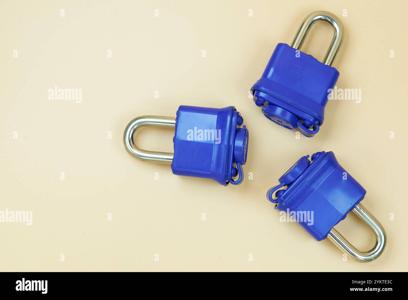 Padlock with blue plastic insulation and key, on a beige background ...
