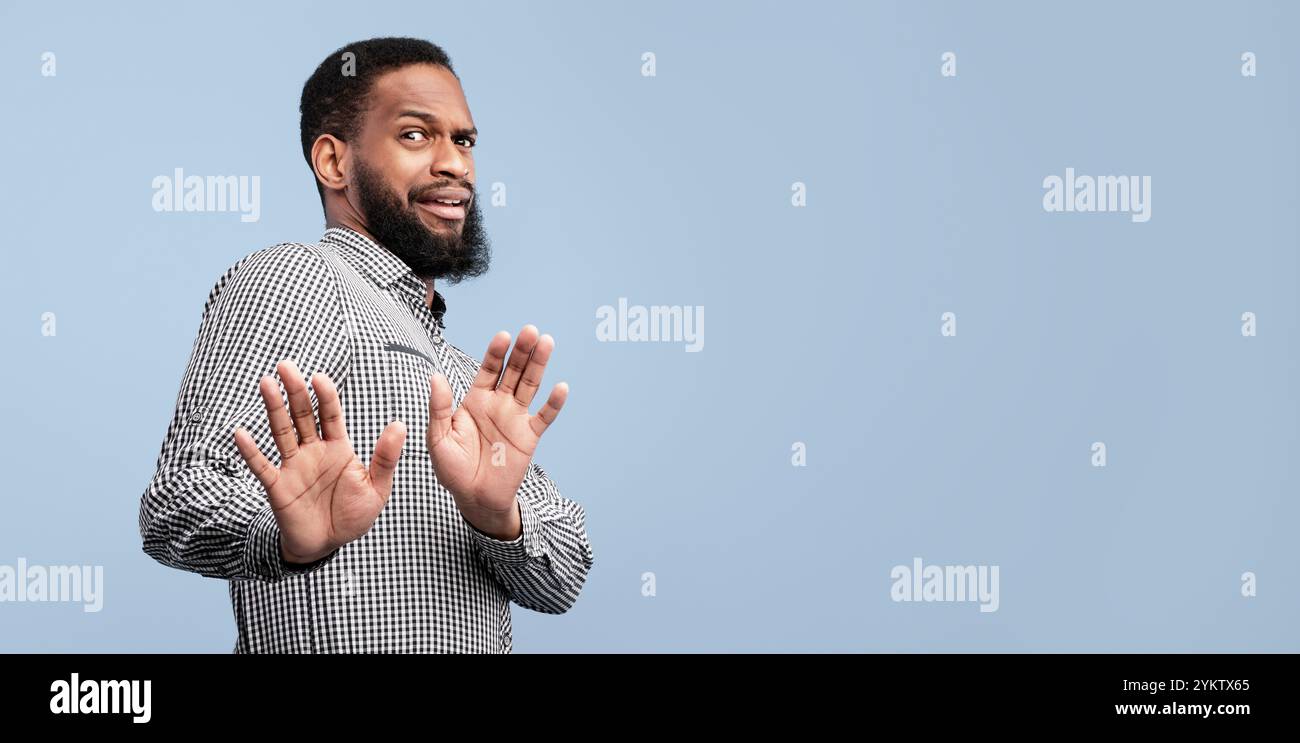 Shocked black man with disgusted face at blue studio Stock Photo - Alamy