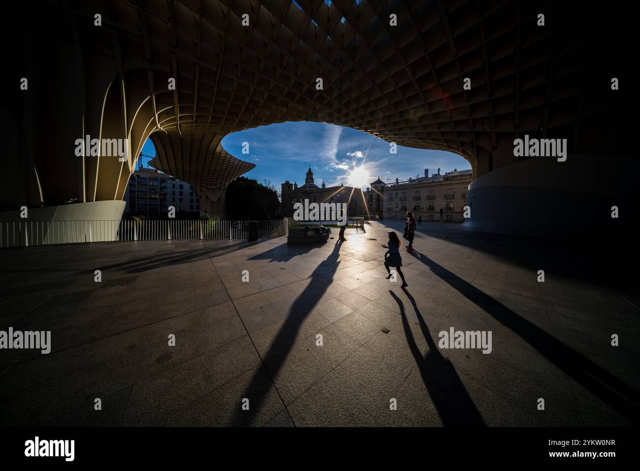 A striking image of silhouetted figures walking beneath Las Setas in ...